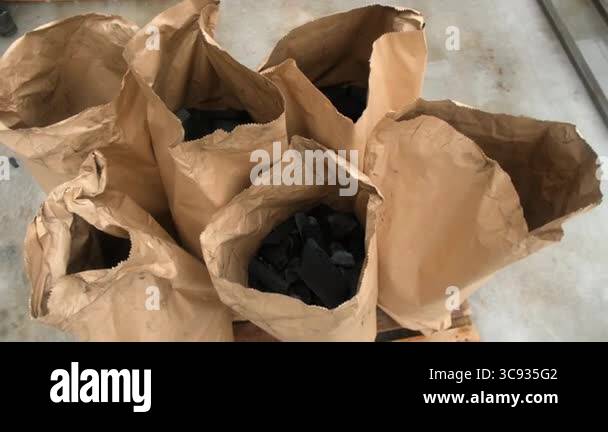 Coal charcoal packed in paper bags on factory production line ...