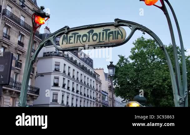 Ornate art nouveau Metropolitain sign illuminates the Parisian twilight ...