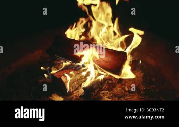 Crackling log fire with bright, detailed flames in close-up view ...