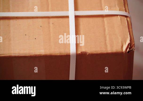 Unboxing. Hand opening brown cardboard box, shipment package, cutting a ...