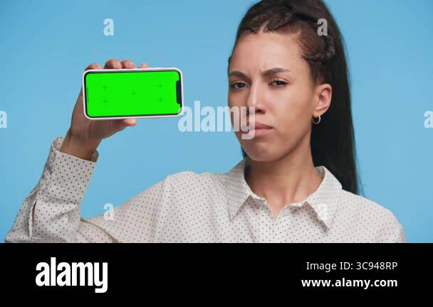Unhappy woman shaking head in disapproval while showing smartphone with ...