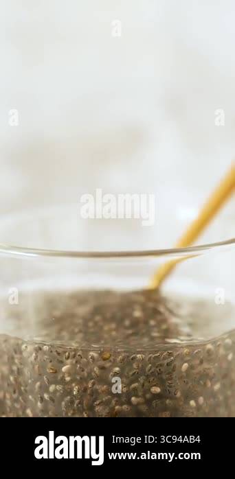 Vertical video showing chia seeds suspended and expanding in water ...