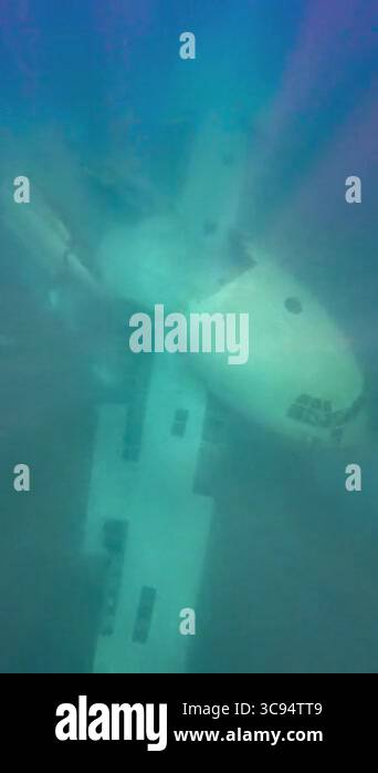 Underwater view of a large submerged airplane wreck resting on the ...