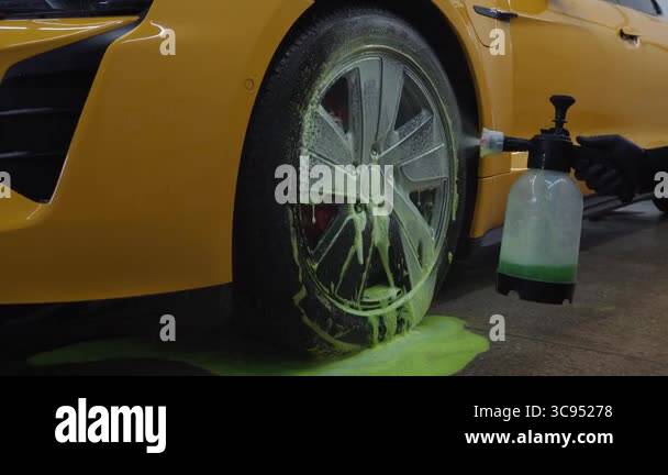 Man uses spray with green soap solution for car detailing at the ...