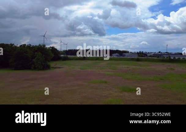 Aerial view of a large parking lot full of cars near a wind farm and ...