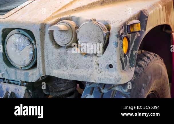 A military vehicle stands prominently its exterior coated with dust ...