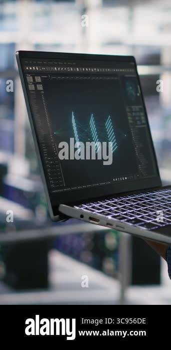 Vertical video Close up of admin in data center using laptop to monitor ...