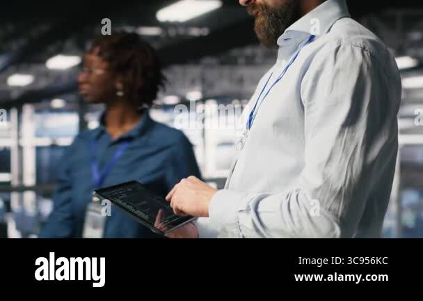 Programmers on data center industrial platform checking code on tablet ...