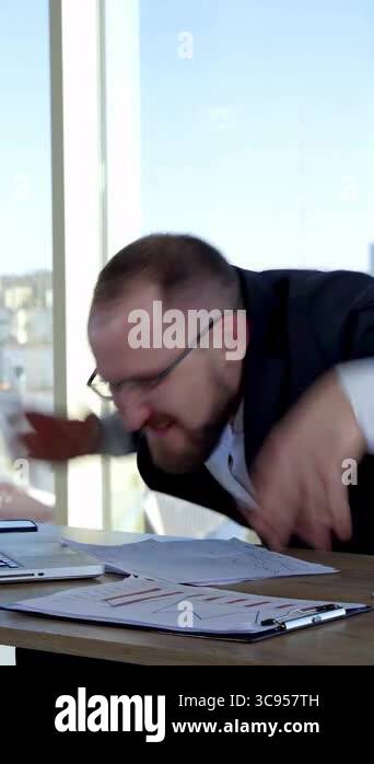 Businessman sitting at office desk. Angry worker looking at computer ...