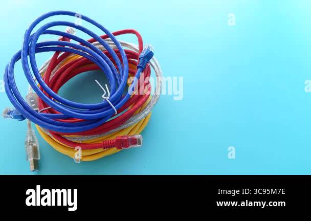 Various cables in bright colors are neatly coiled on a blue background ...