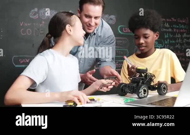 Caucasian teacher pointing at laptop screen while explain car model ...