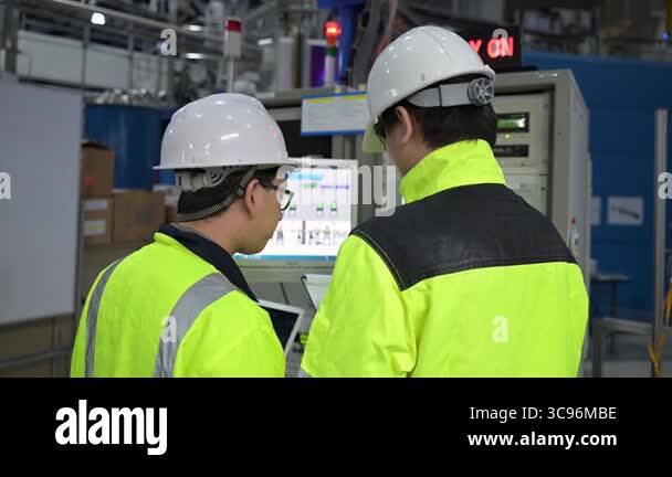 Inside large Industry Factory Male Computer Engineers Works on Personal Computers coding program ...