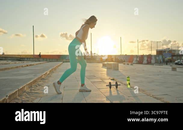 Fitness woman performing one arm dumbbell rows outdoors Stock Video ...
