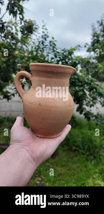 antique jug in hand. vintage tableware. ancient jug. archaeological ...