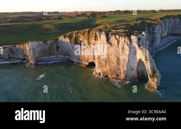 Iconic chalk cliffs and turquoise waters of Etretat glow under sunlight ...