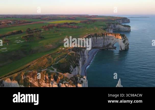 Iconic chalk cliffs and turquoise waters of Etretat glow under sunlight ...