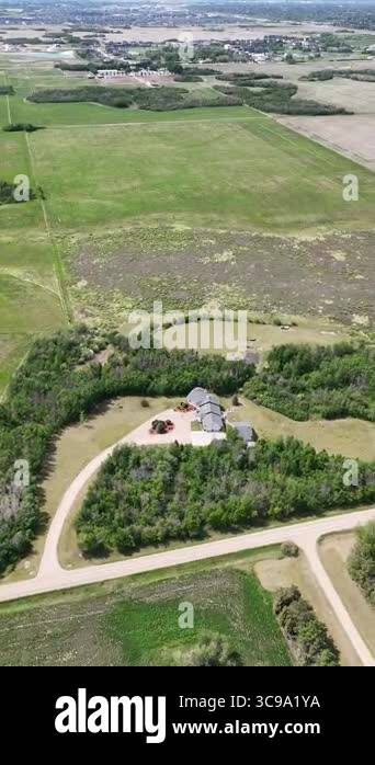 Rural area with a dirt road and a house. The house is surrounded by ...