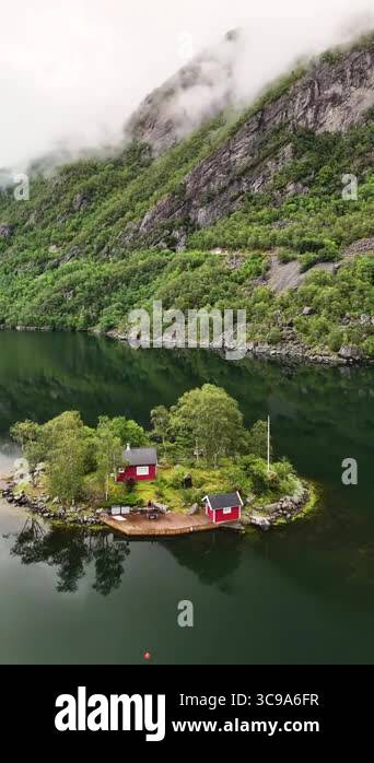 Nestled amidst the stunning landscape of Norway, charming red cabins ...