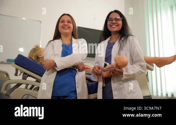 Two healthcare professionals pose with training dolls in a clinical ...