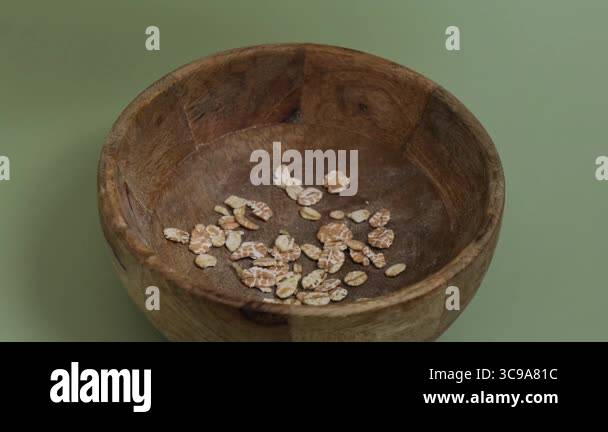 Raw oatmeal porridge in green background copy space. Whole spelt grain ...