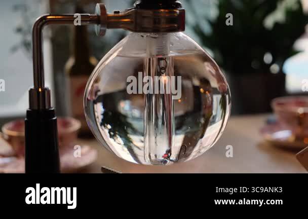 Modern tea brewing device making Chinese Pu-erh tea. Close-up of glass ...