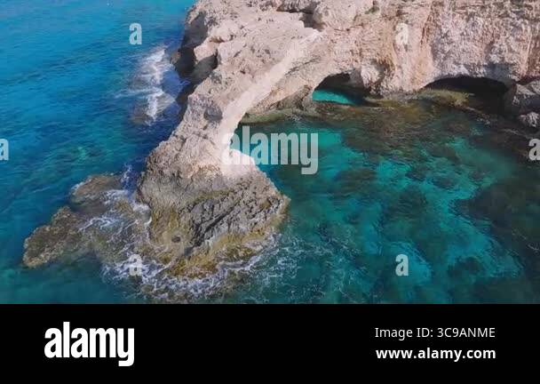 Smooth flyover of the Love Arch in Ayia Napa, Cyprus, showcasing the ...
