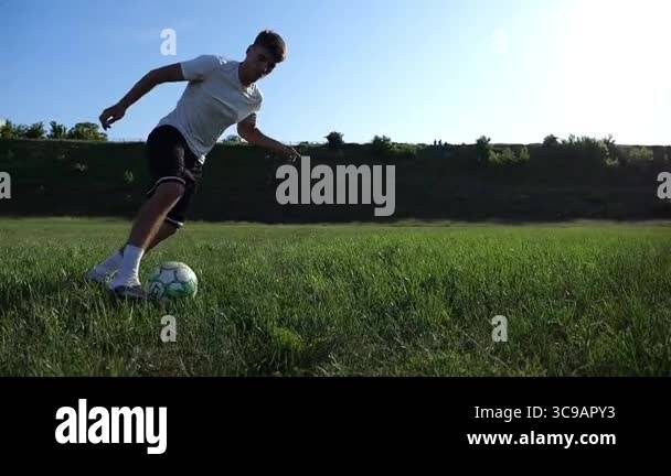 Professional footballer in uniform shows tricks with ball while running ...