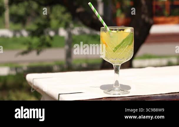 Lemonade in a glass goblet on a blurred background of nature. Lemonade ...