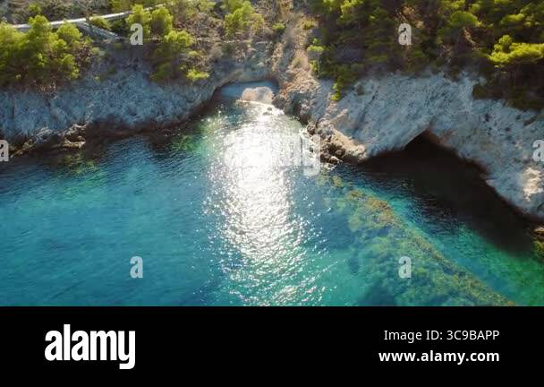 Hidden beach cove with crystal waters and rocky terrain in summer ...
