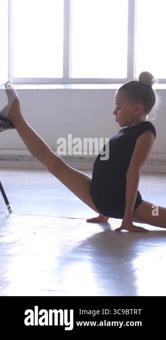 Girl performing splits during a dance rehearsal in a studio, focusing ...