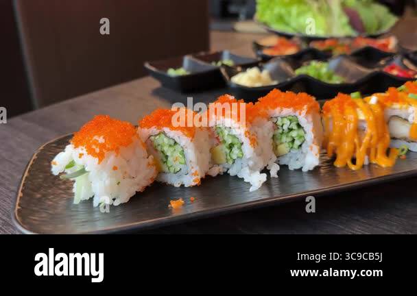Sushi platter with assorted rolls, fish roe, sesame, sauce and ginger ...