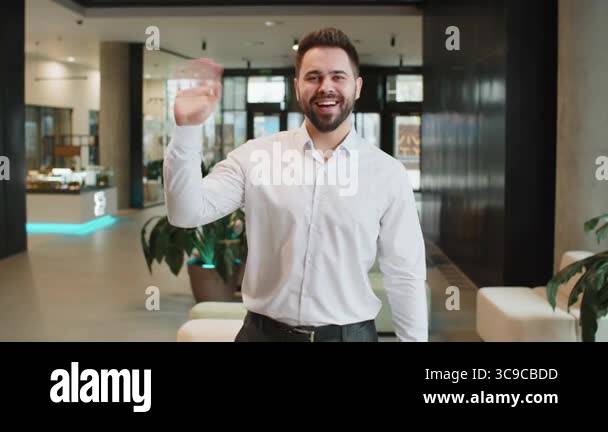 Hello. Happy young Caucasian businessman employee waves hand hi gesture ...