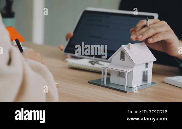 real estate agent showing house model and contract to client Stock ...