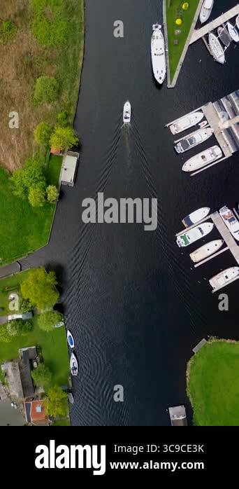 A top-down view of a marina with multiple boats docked along wooden ...