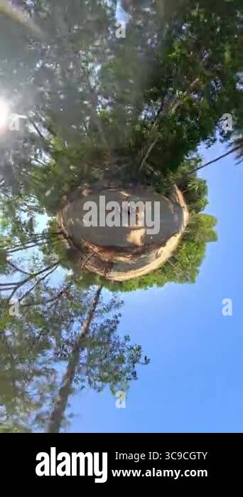 A thrilling tiny planet view captures people riding a scooter through a ...