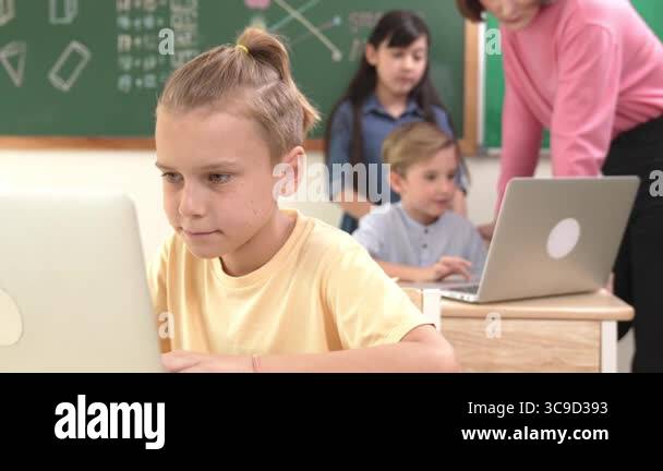 Caucasian boy focus on programing system while looking at camera ...