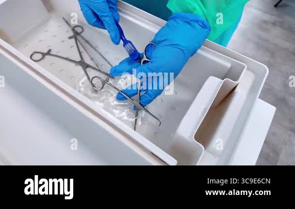 Close-up shot of a medical worker in blue gloves scrubbing surgical ...