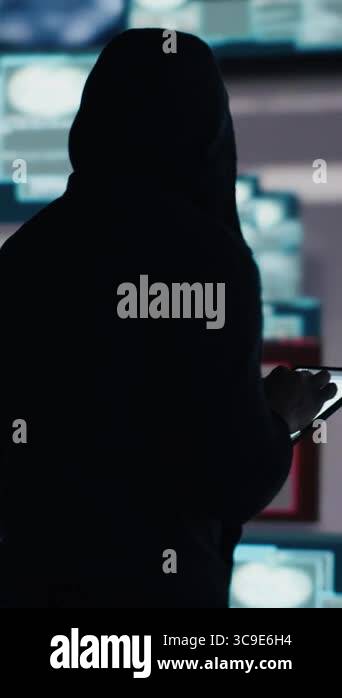 Vertical Video Male hacker breaking into a system in stealth mode by programming code, bypassing ...