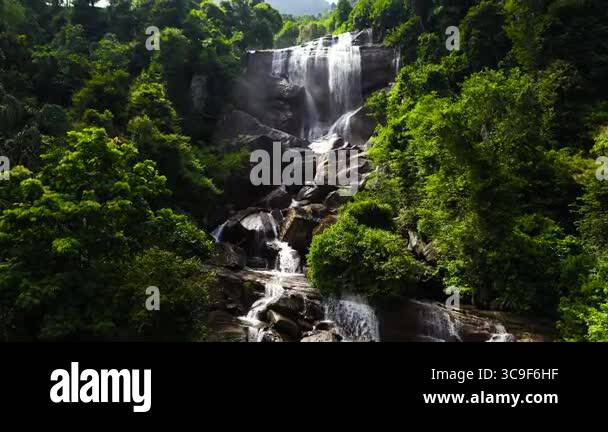A beautiful waterfall among the rainforest and vegetation. Olu Ella ...