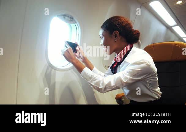 Airline flight attendant takes a photo through an airplane window ...