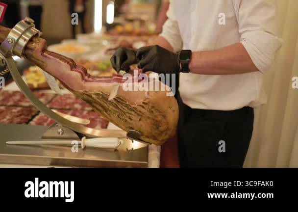 Chef meticulously slicing jamon iberico at a buffet table Stock Video ...