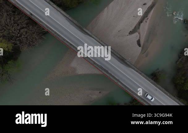 A sequence of aerial shots showing a progressive pullback from a rural bridge crossing a ...