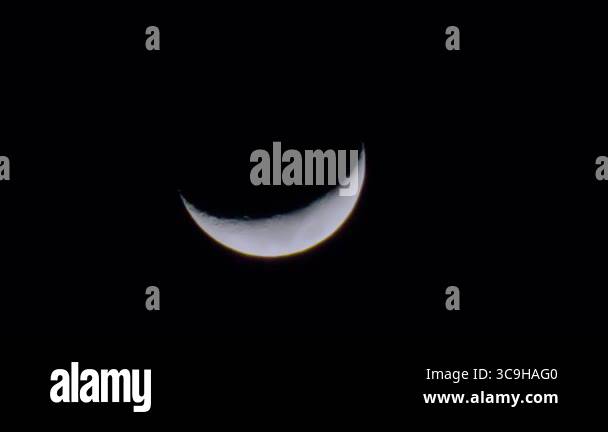 A close-up view of a crescent moon against a dark night sky, showcasing ...