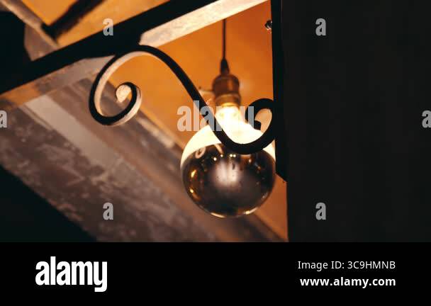 A vintage-style hanging light fixture with a glass bulb, casting a warm ...