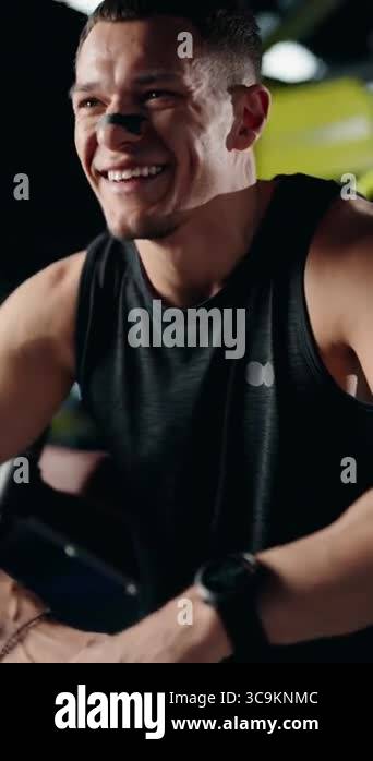 A fit, happy man smiles during his workout at the gym. He takes a break ...