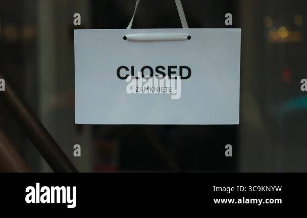 A white sign with the word CLOSED and its Polish translation ZAMKNIETE ...
