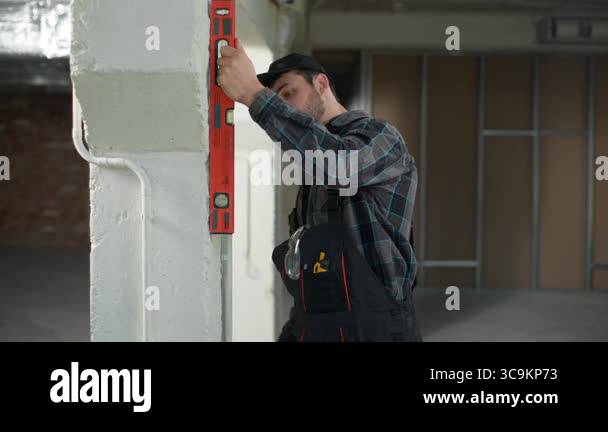 Builder engineer Caucasian man measuring wall with ruler on ...