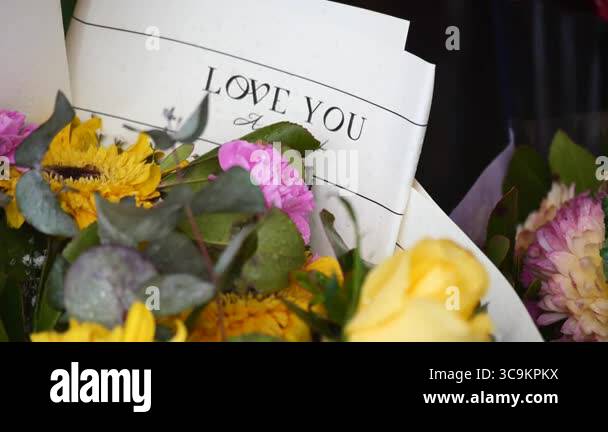 Colorful bouquet of flowers features a note expressing love and ...