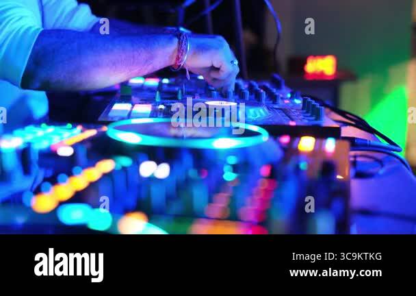 Dynamic DJ performance with colorful lighting, mixing equipment and a ...