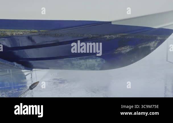 High pressure water tool stripping old antifouling paint from boat hull ...